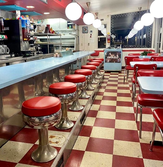 Those red vinyl stools lined up like eager breakfast soldiers, ready for duty on the checkered battlefield of comfort food.