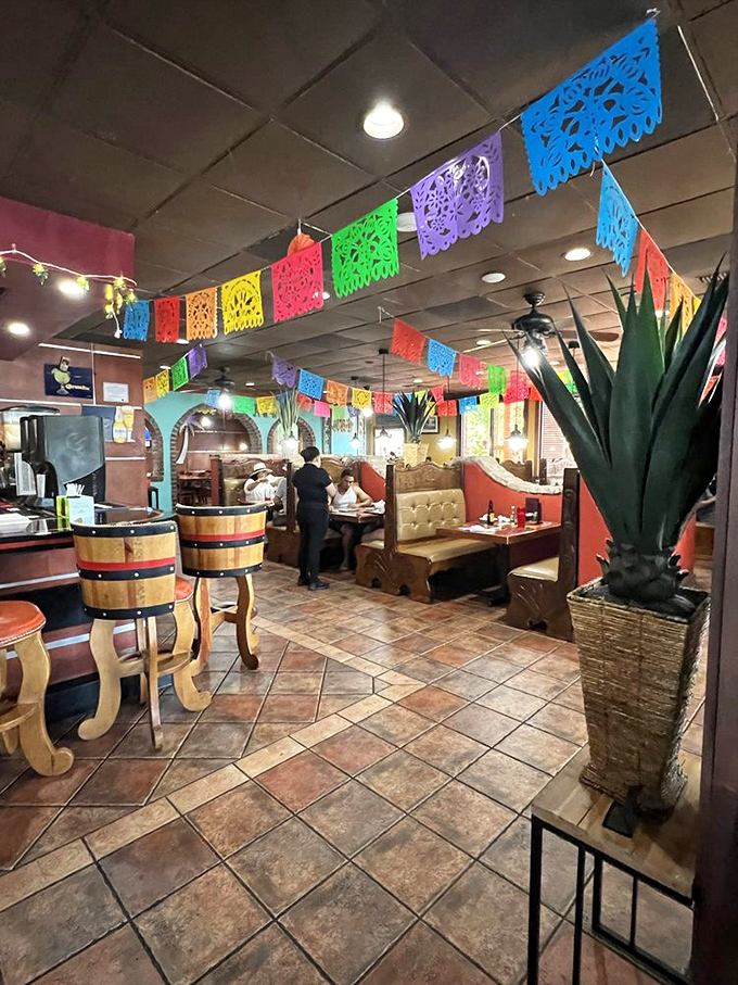 Colorful papel picado banners dance overhead while barrel-style chairs await hungry patrons. This isn't decoration&mdash;it's a portal to Mexico.