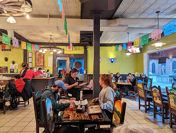 Vibrant papel picado banners dance overhead while diners enjoy authentic Mexican cuisine in a space that feels like a direct portal to Veracruz.