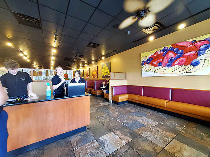 Inside, vibrant fruit artwork and cozy burgundy booths create that perfect "I could linger here all morning" atmosphere that every great breakfast spot needs.