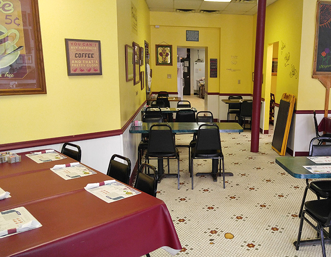 Sunshine-yellow walls and burgundy accents create that rare atmosphere where strangers become regulars and regulars become family. Comfort begins before the food arrives.