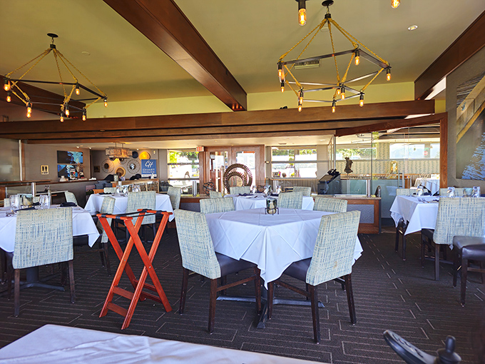 The dining room balances elegance with comfort, where nautical-inspired lighting fixtures hover above like sophisticated jellyfish in a sea of culinary possibilities.