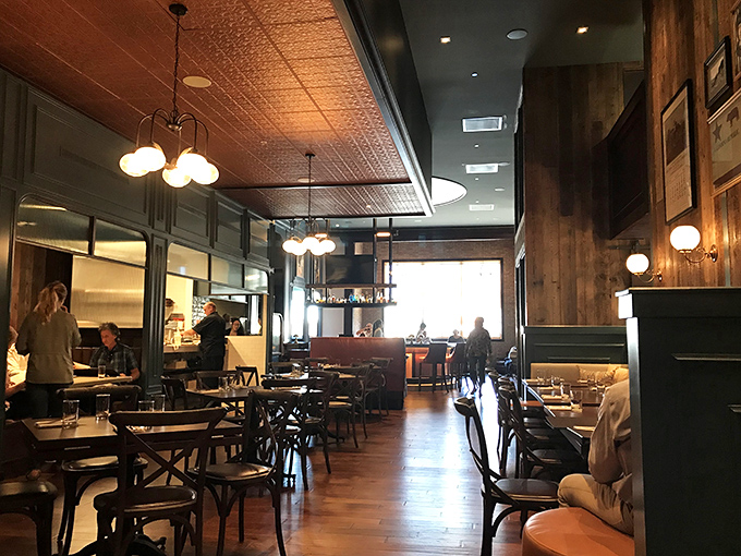 Step inside to discover a warm, wood-paneled sanctuary where pressed tin ceilings and vintage lighting create the perfect backdrop for serious food enjoyment.