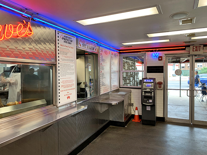 The neon-lit interior gleams with stainless steel efficiency&mdash;a temple of sandwich craftsmanship where ordering is an art form.