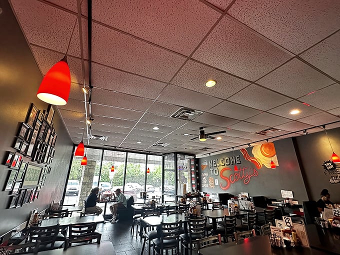 Red pendant lights cast a warm glow over tables where breakfast dreams come true. The "Welcome to Scotty's" mural isn't just decoration—it's a promise.