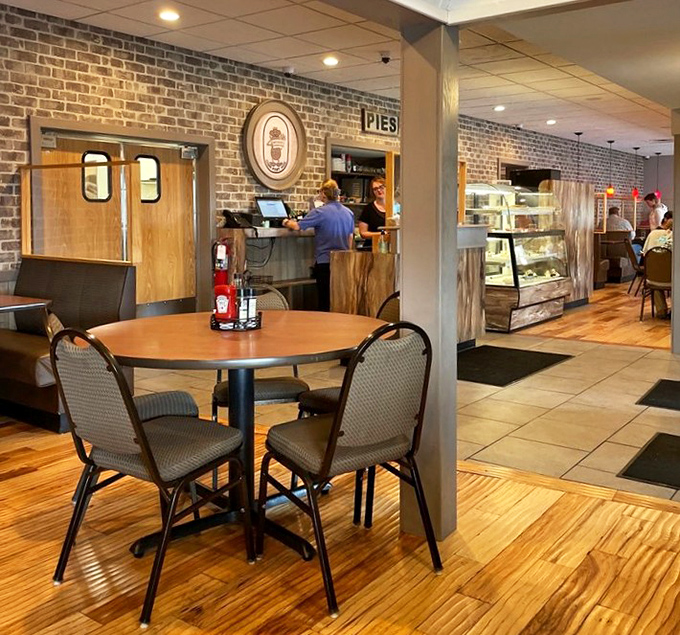 Exposed brick walls and wooden floors create that perfect "been here forever" vibe. The pie display case silently argues for dessert first.