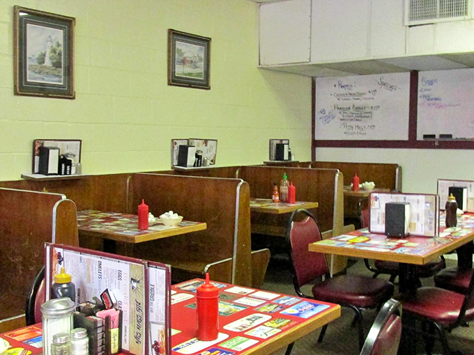 Wooden booths worn smooth by years of elbows and conversations. The yellow walls and lighthouse prints say "welcome home" before you've even ordered.