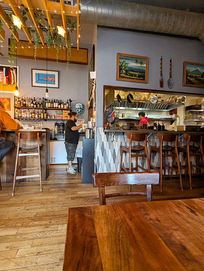 Where exposed beams meet tropical plants, creating an atmosphere that feels like dining in a friend's stylish kitchen.
