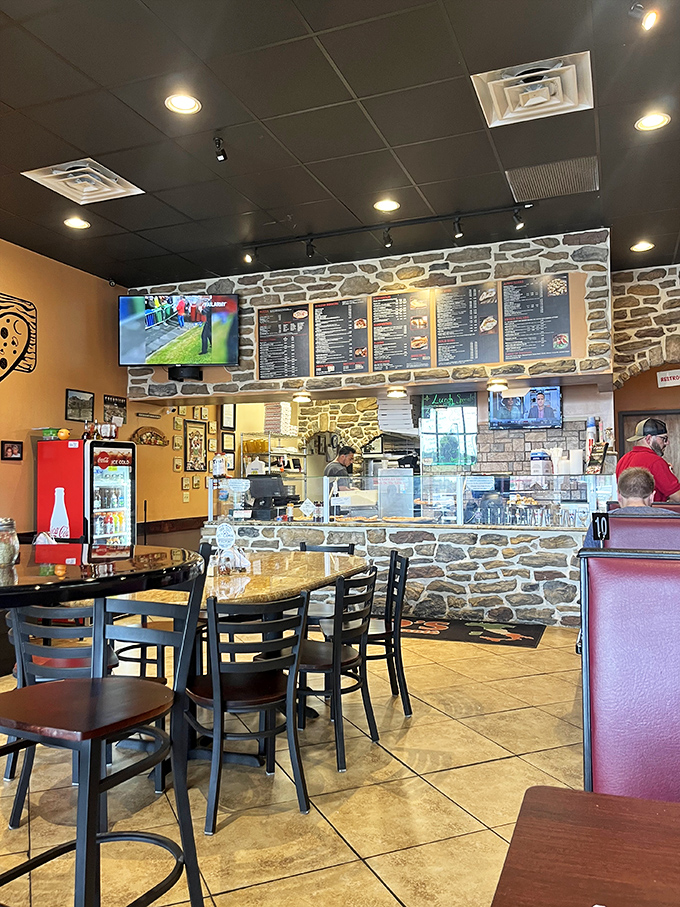 Stone walls and warm lighting create that classic pizzeria atmosphere where memories are made one slice at a time.