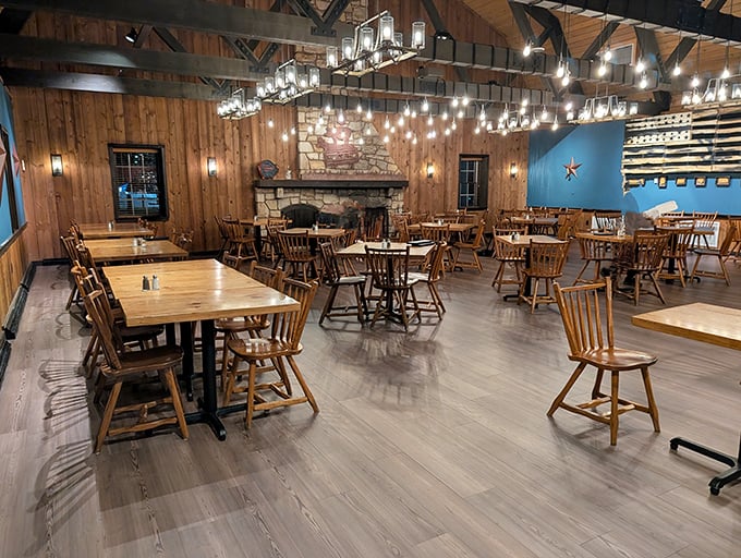 Rustic wooden beams meet modern comfort in this dining room where the stone fireplace promises warmth and the tables promise delicious memories.