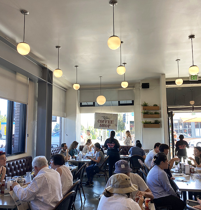 Globe pendant lights cast a warm glow over the bustling dining room, where breakfast dreams come true one plate at a time.