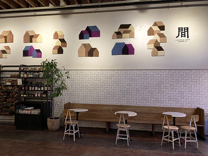 Minimalist wooden houses adorn white walls above subway tiles, creating a space that's both Instagram-worthy and genuinely comfortable—like Scandinavian design with California soul.