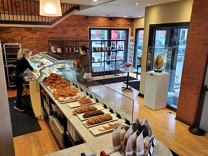 Behind this gleaming counter lies a wonderland of French pastry perfection that would make Julia Child weep with joy.