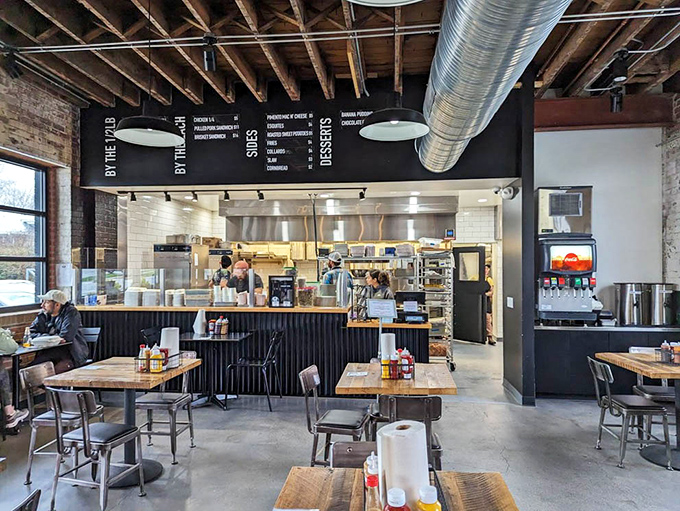 Industrial-chic meets Southern comfort in this airy space where exposed brick, wooden beams, and the promise of barbecue create perfect harmony.