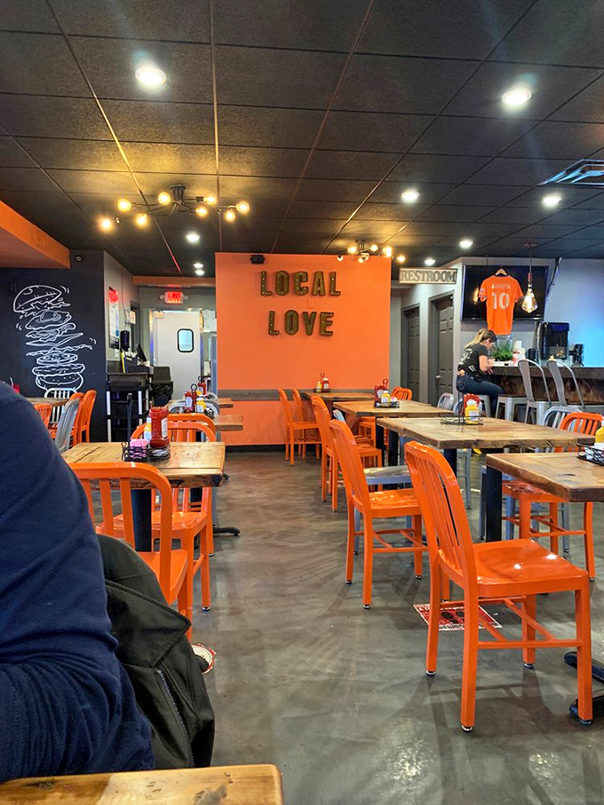 Step inside and the vibrant orange chairs against rustic wooden tables immediately signal this isn't your average burger joint.
