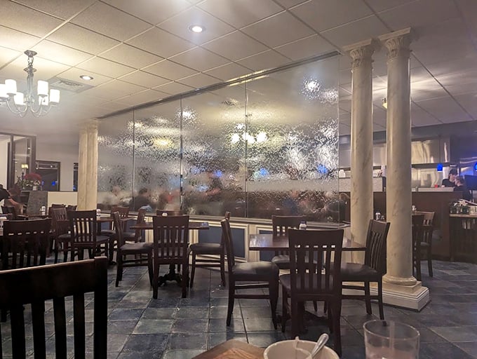 Classical columns meet contemporary dining. The textured glass dividers and slate floors create an atmosphere that whispers "Athens" while shouting "come sit awhile!"