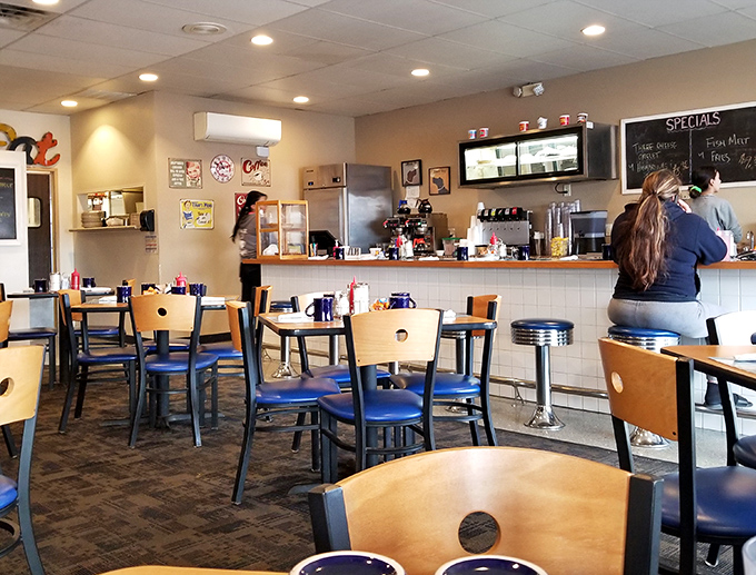 Classic diner simplicity at its finest—wooden chairs, blue seats, and the promise of conversations that matter over coffee that keeps coming.