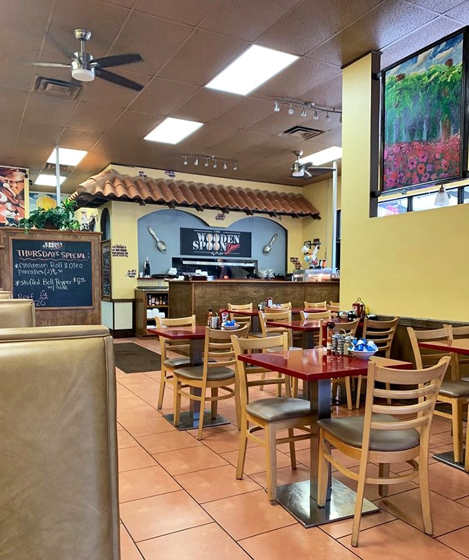 Warm yellow walls, wooden accents, and colorful artwork create the perfect backdrop for morning conversations and coffee refills.