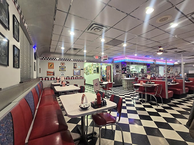 The black and white checkered floor plays perfect host to cherry-red booths and vintage decor, creating the quintessential diner atmosphere that feels like a movie set come to life.