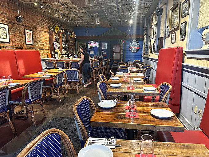 Blue chairs, red booths, and exposed brick walls create the perfect backdrop for culinary drama. Like a well-directed film, every element plays its part.