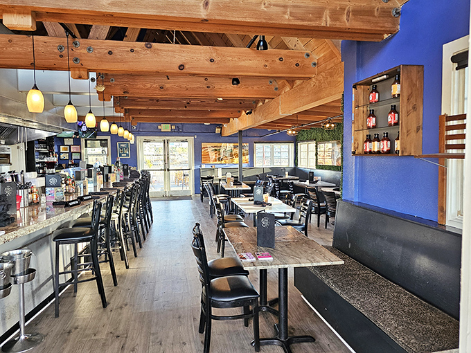 Exposed wooden beams and vibrant blue walls create the perfect nautical backdrop for seafood indulgence, like dining inside a stylish ship that never sails away.
