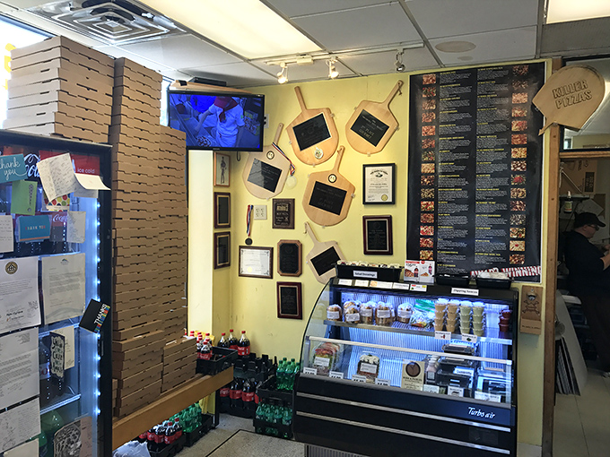 Awards line the walls like trophies in a champion's case, while stacks of pizza boxes stand ready for the dinner rush &ndash; organized chaos at its finest.