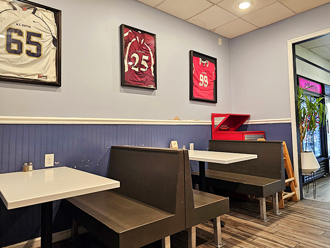 Sports memorabilia watches over booths where cheesesteak legends are born, one perfect bite at a time.