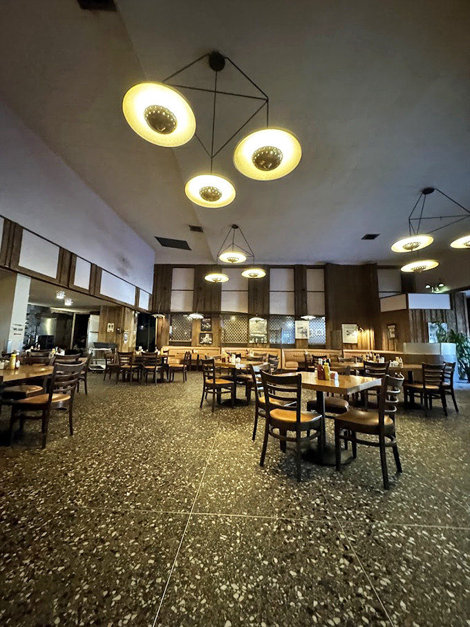 Mid-century modern meets comfort food heaven. Those distinctive ceiling fixtures have illuminated countless late-night conversations and early morning recoveries.