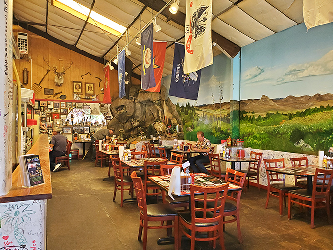 Step inside to a world where wood-paneled walls, hanging flags, and that stunning landscape mural create the perfect backdrop for serious eating.