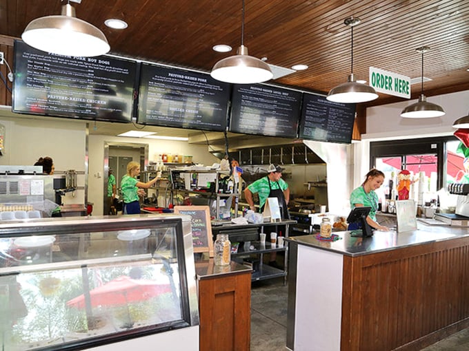 Where burger magic happens. The open kitchen design lets you witness your meal's creation while staff in green shirts orchestrate a delicious symphony of sizzles and aromas.
