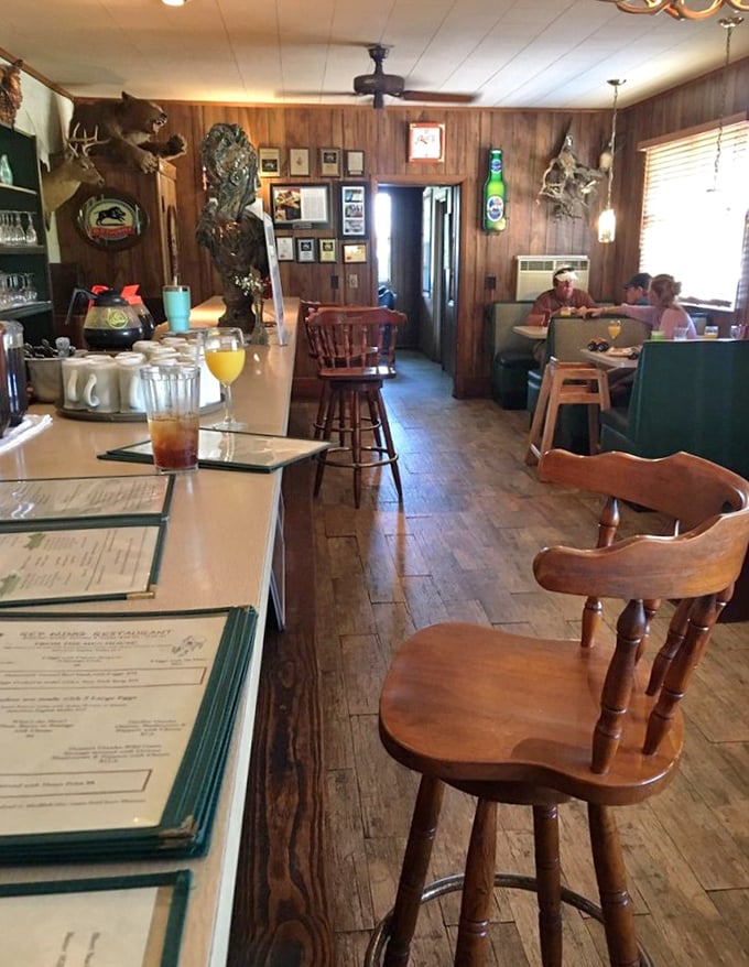 Wood-paneled walls adorned with hunting trophies set the perfect backdrop for this no-nonsense dining experience where comfort meets flavor.