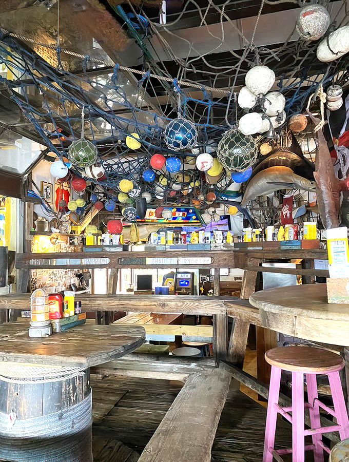 Nautical chaos meets rustic charm in this interior where fishing floats and nets create a ceiling tapestry that would make Neptune feel right at home.