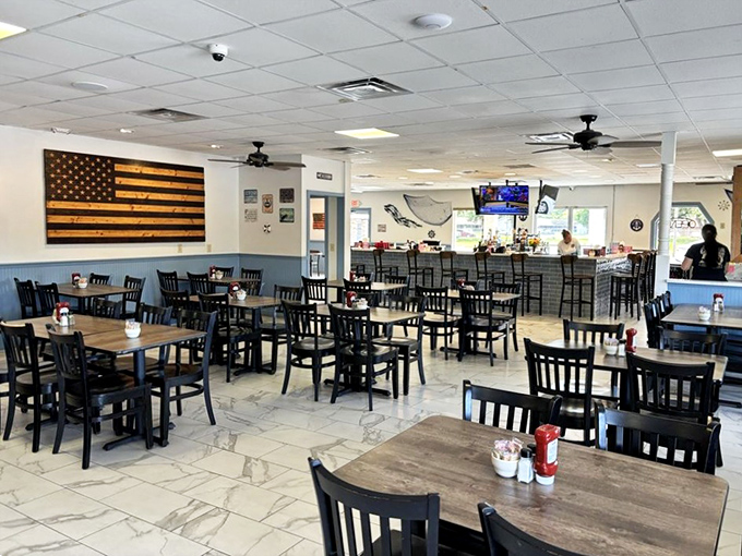 Simple black chairs, wooden tables, and an American flag crafted from wood create an atmosphere where pretension goes to die and appetite comes alive.