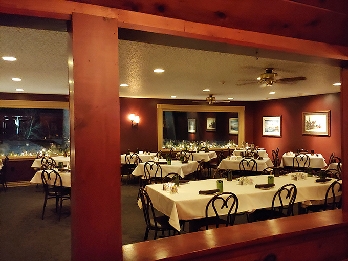 Classic supper club elegance: white tablecloths, warm wood tones, and picture windows create the perfect backdrop for memorable meals and lakeside views.