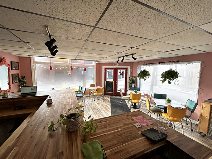 Sunlight streams through large windows, illuminating pink walls and wooden floors that feel like your stylish Polish grandmother's dream kitchen.