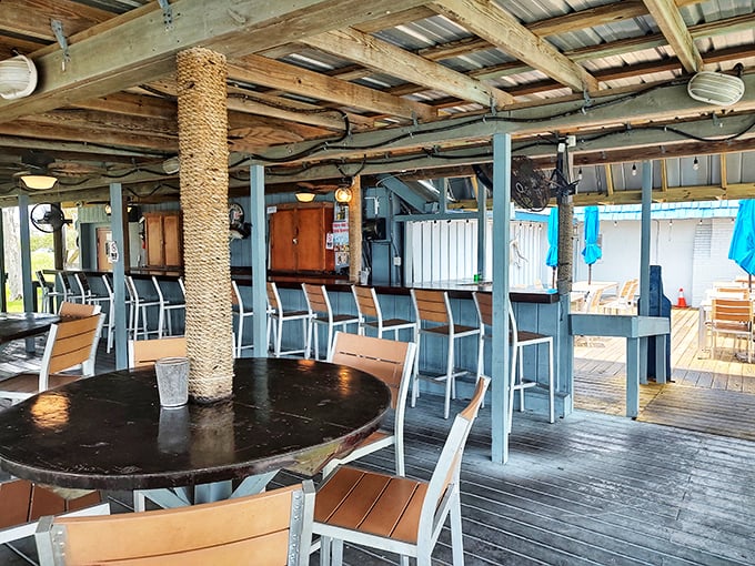 Nautical charm meets practical comfort in this waterfront dining area. Those rope-wrapped pillars didn't wrap themselves, folks—that's dedication to the coastal aesthetic.