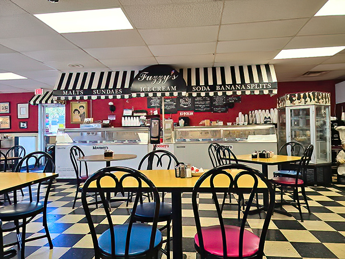 Inside Fuzzy's, the black and white checkered floor and vibrant red walls create that perfect time-capsule diner atmosphere where calories don't count and conversations flow freely.