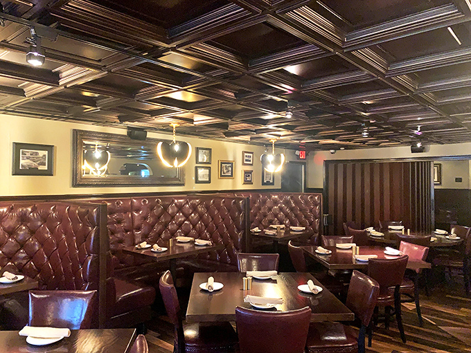Step into a time capsule of classic steakhouse ambiance, where burgundy leather booths and ornate tin ceilings set the stage for carnivorous excellence.