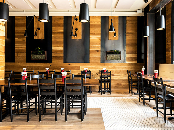 Wood panels and black pendants create the perfect mood lighting for questionable food decisions you won't regret.