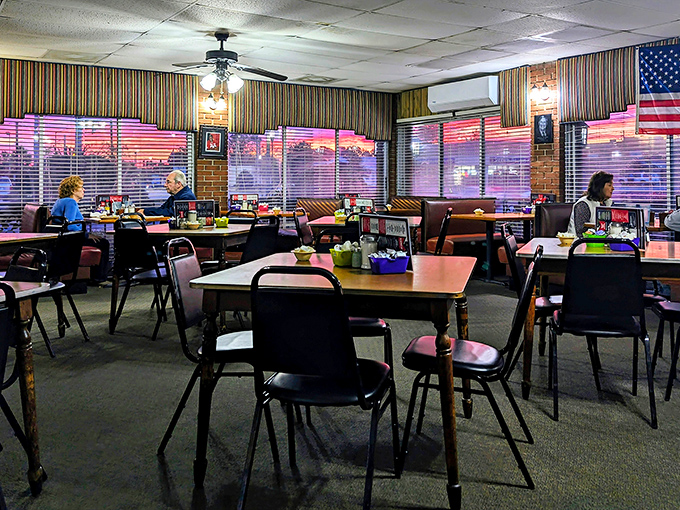 Morning light streams through striped curtains, casting a warm glow across tables where locals gather for their daily ritual of coffee and conversation.