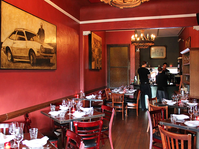 Rich red walls and eclectic artwork transform this intimate dining room into a cozy sanctuary where comfort food dreams come true.