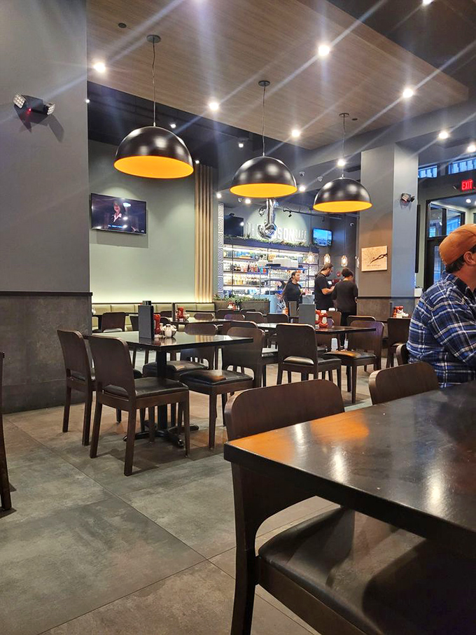 Inside, dome pendant lights with warm yellow interiors cast a golden glow over the contemporary space, making even Monday mornings feel civilized.
