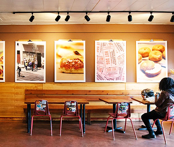 Wood-paneled walls showcase oversized food photography that serves as both art installation and delicious warning of what's to come.