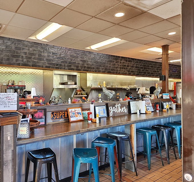 Counter seating puts you front-row for the breakfast show. Blue metal stools, brick walls, and that "gather" sign&mdash;they had me at hello.