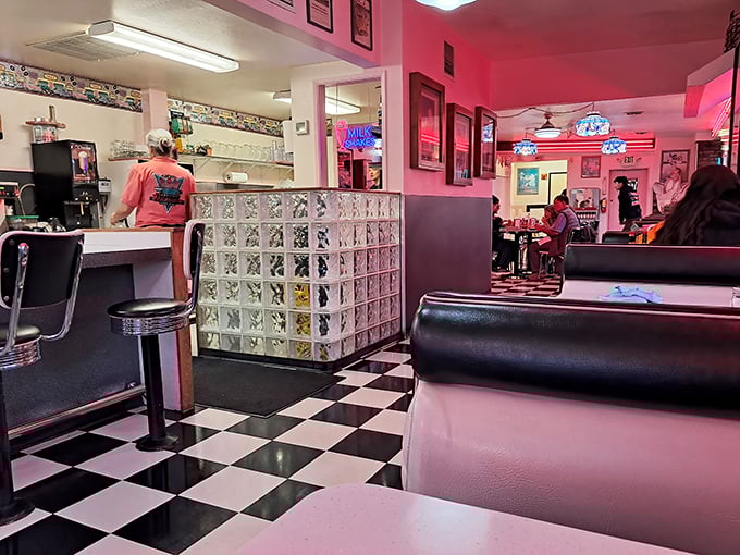 The classic black-and-white checkered floor and pink-hued lighting create that perfect "Edward Hopper painting meets Happy Days" vibe we all crave.