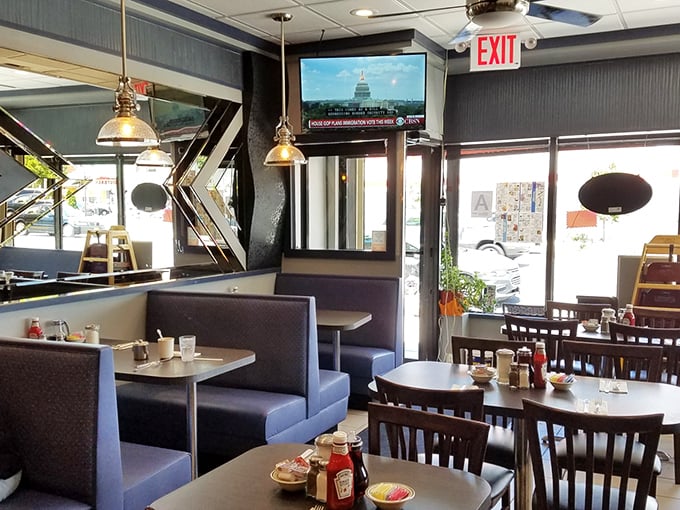 Classic blue booths and pendant lighting create that perfect diner atmosphere—where conversations flow as freely as the coffee refills.