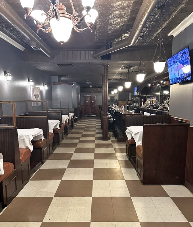 That checkerboard floor leads you through a dining room where memories are made. The pressed tin ceiling and warm lighting whisper, "Stay awhile, the food is worth it."