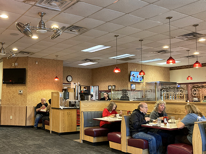 Classic diner ambiance with those signature red pendant lights &ndash; where conversations flow as freely as the coffee. The backdrop to countless local stories.