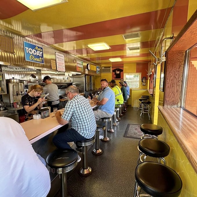 Fourteen stools, one counter, zero pretension. The yellow ceiling and bustling atmosphere create the perfect symphony of classic American diner culture.