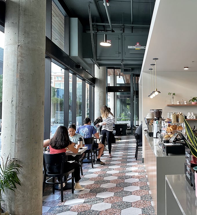 Modern industrial meets cozy diner inside Glo's, where concrete columns and hexagonal floor tiles create the perfect backdrop for morning conversations and coffee refills.